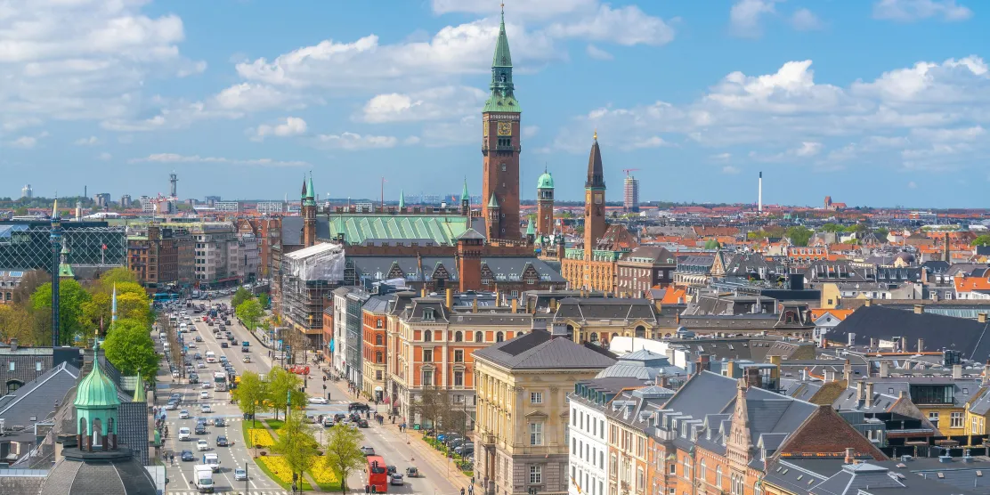 Aerial view of city buildings and a tall clock tower in Copenhagen, Denmark.