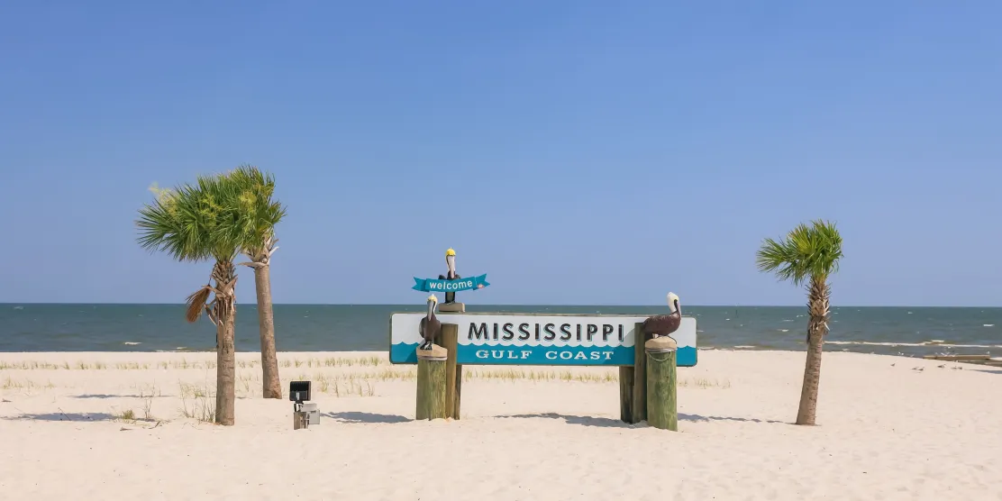 Sandy beach and calm ocean waters in Gulfport, Mississippi.