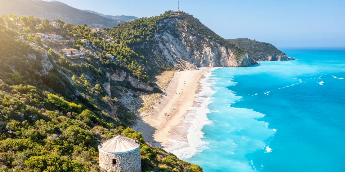 Aerial view of Myrtos beach in Greece with white sand and steep cliffs