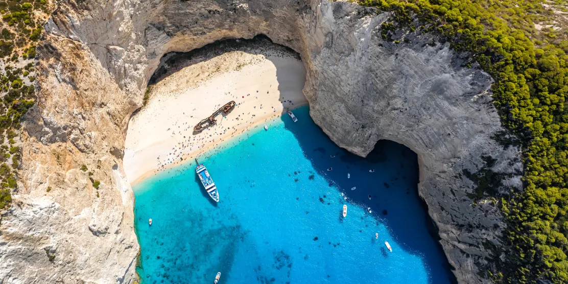 Navagio Shipwreck Beach in Greece surrounded by high limestone cliffs