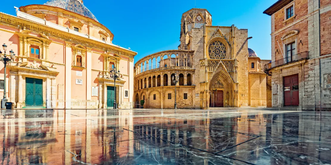 Historic stone cathedral and reflective courtyard plaza.
