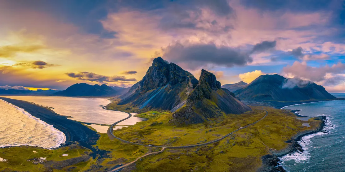 Aerial view of a rugged green mountain peninsula in Iceland.