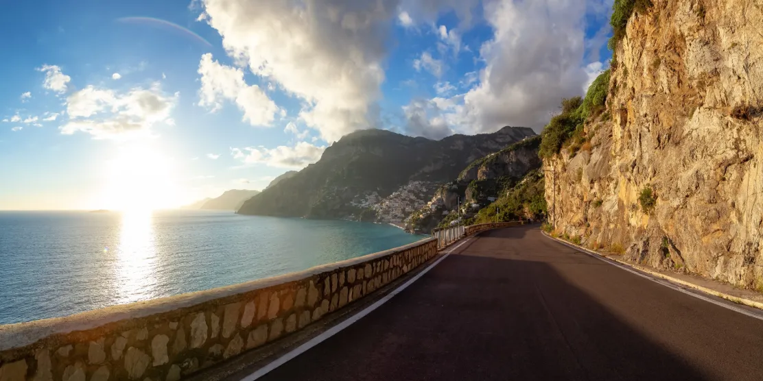 Scenic road trip route along the Amalfi Coast in Italy, overlooking the Mediterranean Sea and coastal mountains