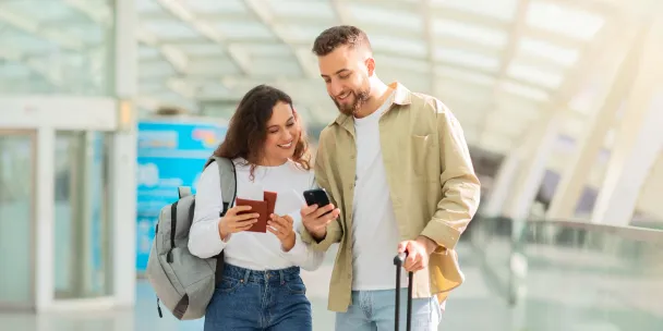Couple checking phone in the airport.