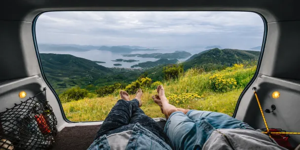 cover of the best road trip routes in Europe post: couples watching a landscape from the back of a van